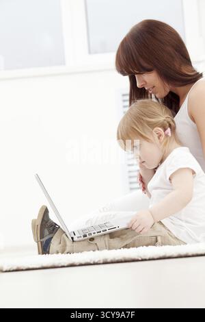 Parent and child looking at computer Stock Photo - Alamy