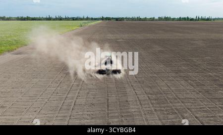 Aerial view of a tractor working with a clod-breaker roller during ...