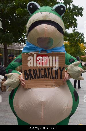 A protester wearing an inflatable frog costume and waving an American ...