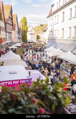View of a lively festival tent with many people and colourful roof ...