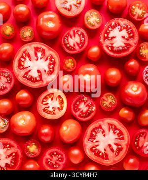 Top view of whole and cut cherry tomatoes on pink background Stock ...