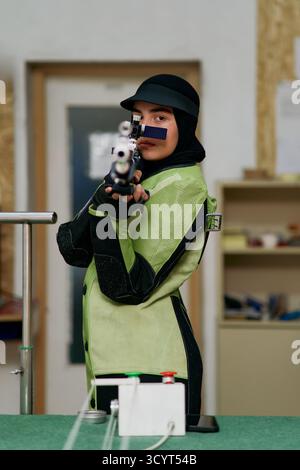Female athlete wearing professional shooting uniform and hijab ...