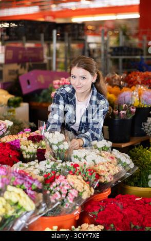 Girl salesman takes out bunch of hydrangea from showcase Stock Photo ...