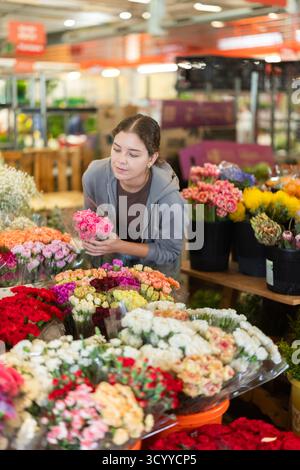 Female customer chooses a bouquet of carnations in flower shop Stock ...