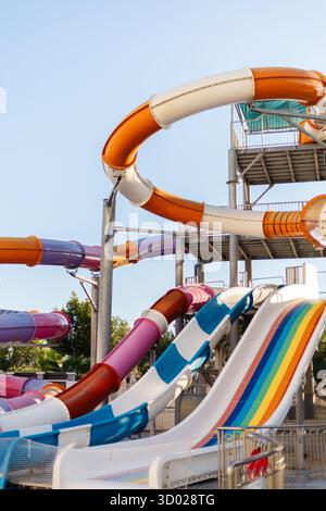 Bright colored water slides in the water park against the blue sky ...