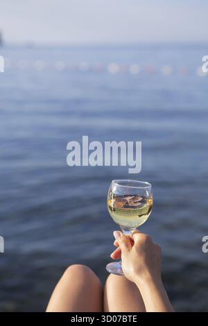 a girl holds a glass of white wine against the backdrop of a lavender ...