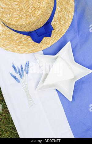 hat, brie cheese in a plate on a blue tablecloth Stock Photo - Alamy