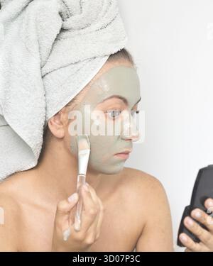 Young Woman Applying Clay Face Mask at Home, Self Care Beauty and ...