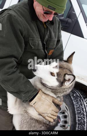Man cuddling with his dog in winter Stock Photo - Alamy