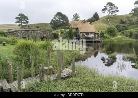 Hobbiton mill and double arched bridge with lake reflection in hobbiton ...