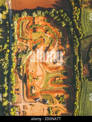 Aerial view of a motocross track winding through lush greenery and ...