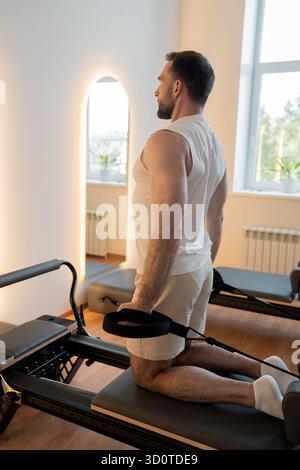 Pilates reformer workout exercises man at gym indoor Stock Photo - Alamy