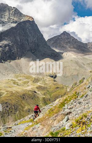 senior woman, riding her e-mountainbike on the famous Bernina express ...