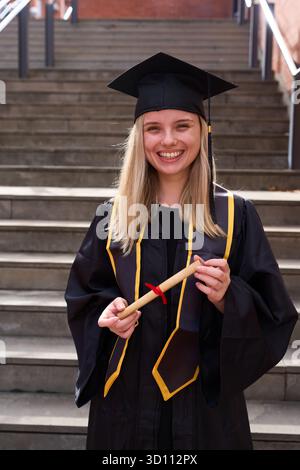 Portrait of happy graduate student holding empty banner. Isolated on ...