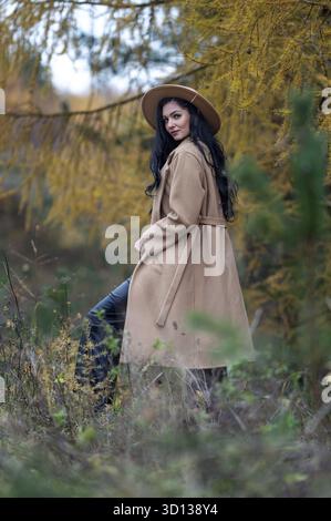Brunette woman in white coat and jeans in Valencia Stock Photo - Alamy