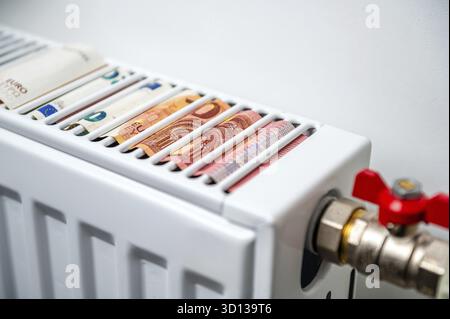 euro banknotes in a central heating radiator, the concept of expensive ...
