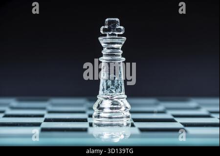 glass chess board game in black background ,selective focus on King ...