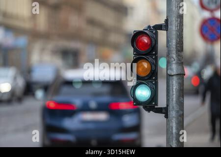 a city crossing with a semaphore on blurred background with cars in the ...