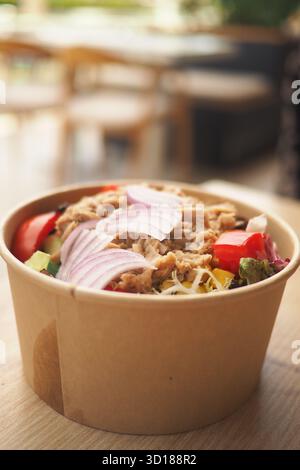Colorful tuna salad with fresh vegetables in a gray bowl on a rustic ...