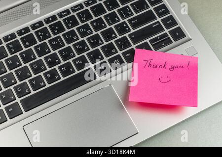 Thank You Note with Smiley Face - A bright yellow sticky note displays ...