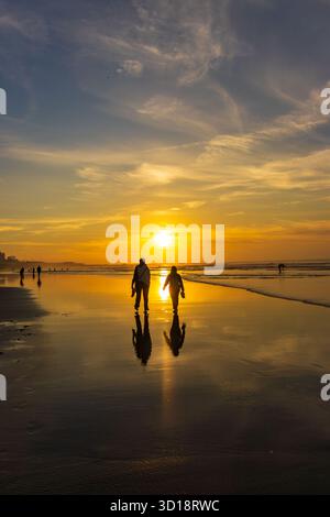 Silhouettes of people enjoying the warm sea during the sunset in Koh ...
