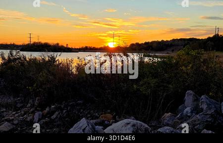 Sunset reflecting across quiet lake Stock Photo - Alamy