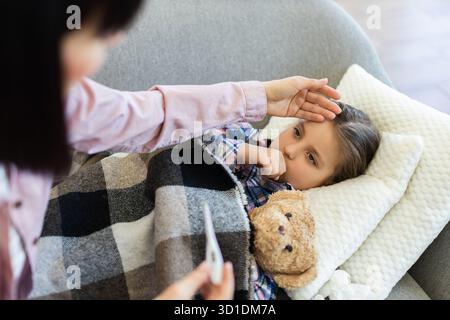 Sick child with a fever being cared for at home Stock Photo - Alamy