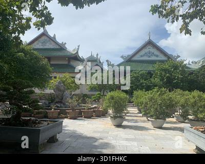 Peaceful Buddhist temple surrounded by lush greenery and bonsai trees ...