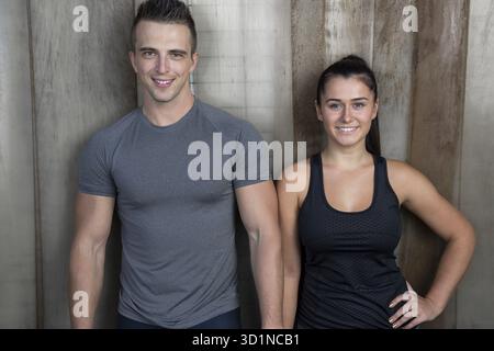 Fit couple after exercise at crossfit gym against rustic background ...