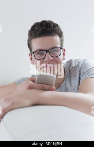 partial view of man using smartphone with blank screen on sandy beach ...