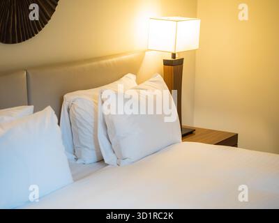Modern interior of bedroom. Burning lamp on wooden nightstand Stock ...