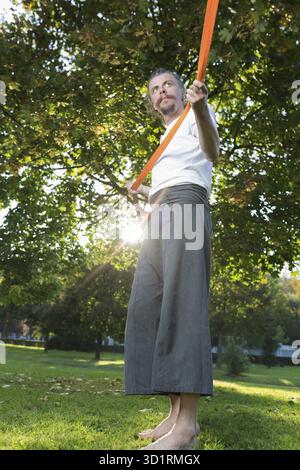 Guy practising slack line in the city park Stock Photo - Alamy