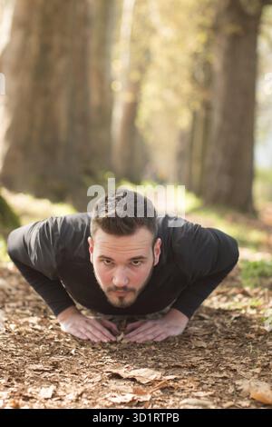young handsome man doing morning exercises in front of his luxury home ...