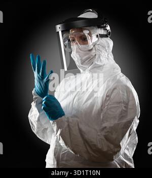 A medical worker wearing protective gear looks at the testing booth at ...
