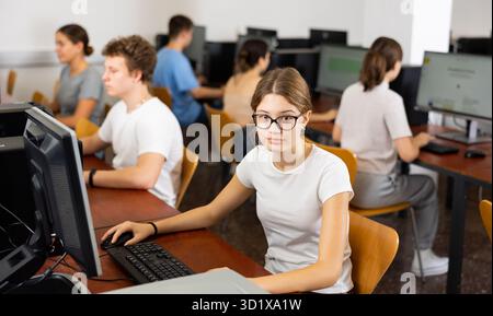 Interested teen girl studying with classmates in school class Stock ...