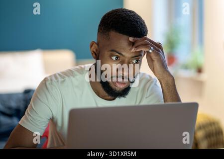 Young African man freelancer feeling tired of monotonous tasks, looking ...