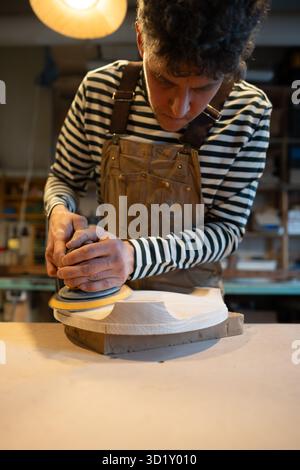 Close up of sanding a wood with orbital sander at workshop electric ...