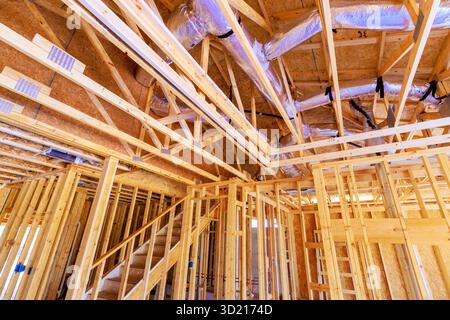 Workers are building wooden frame with ductwork in new construction ...