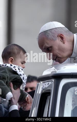 Pope Leo XIV greets a child as he arrives for his weekly general ...