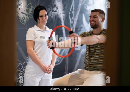Physical Therapy Session with Resistance Ring.A male patient performing ...
