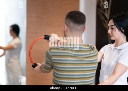 Physical Therapy Session with Resistance Ring.A male patient performing ...