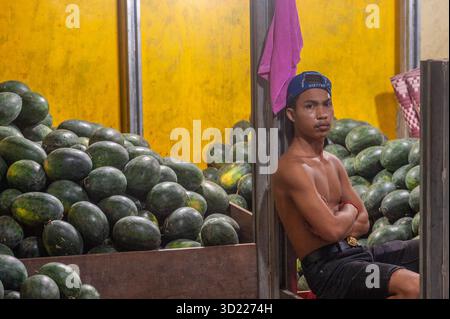 A young Cambodian vendor sells fresh tropical fruit, including durian ...