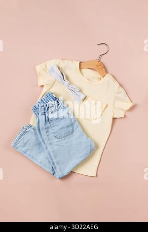 Childish image with jeans and a yellow t-shirt on a pink background ...