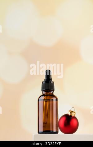 Brown dropper with anti-aging face serum with christmas ball on bokeh ...