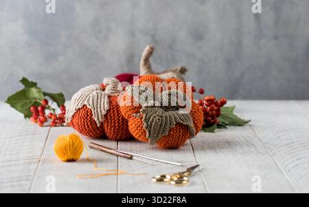 Cute crochet knitted orange pumpkins on black background with a ball of ...