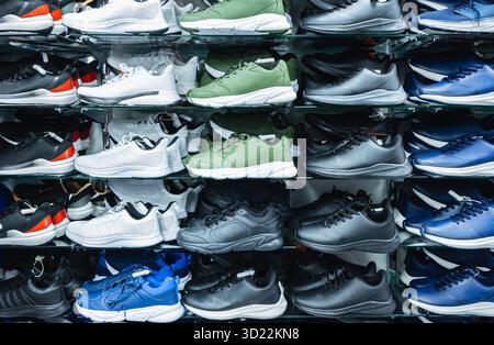 Shop display of a lot of Sports shoes on a wall. A view of a wall of ...