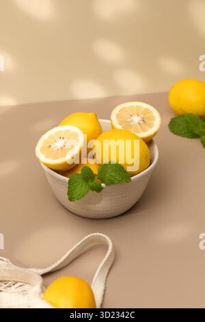 Plate with fresh lemons on light background Stock Photo - Alamy