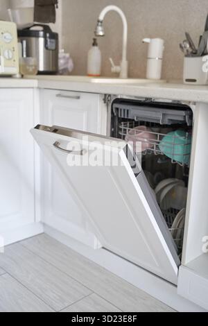 Interior of stylish kitchen with dishes, utensils and sink on counter ...