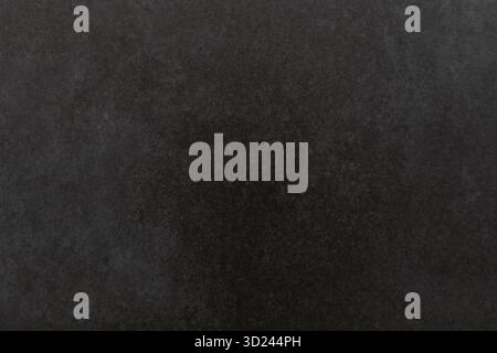 Textured dark surface showing subtle variations in color and tone in an ...