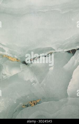 Translucent light green mineral with golden veins and textures in a ...